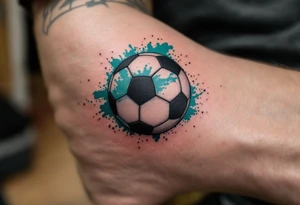 A small behind The Ear soccer ball tattoo in black with a splash of ...